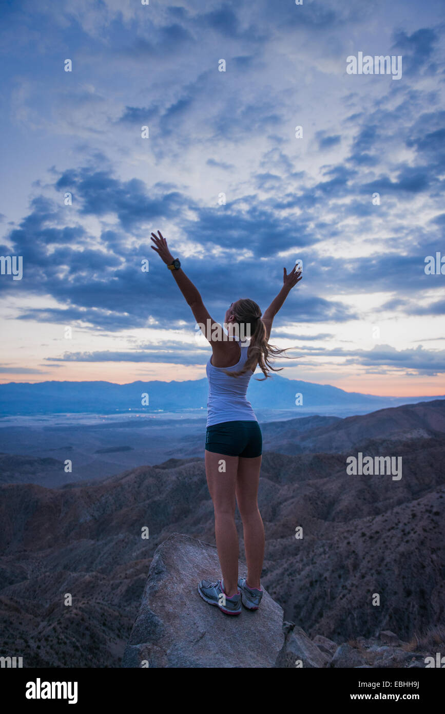 Woman taking break on mountain, Joshua Tree National Park, California ...