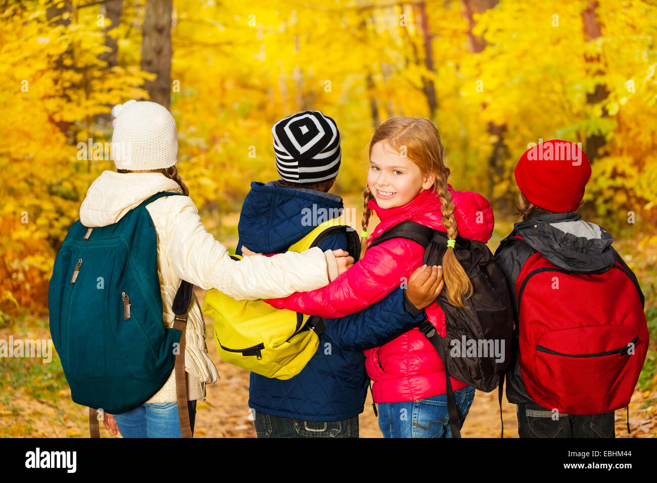 Back view of kids group stand close with rucksacks Stock Photo - Alamy