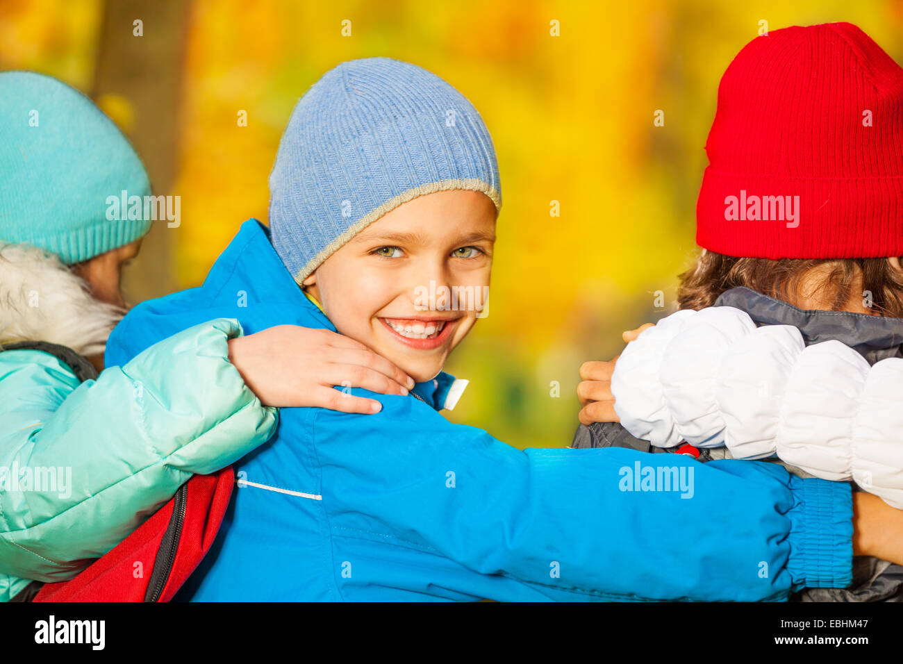 Boy look back with his friends hugging close Stock Photo - Alamy