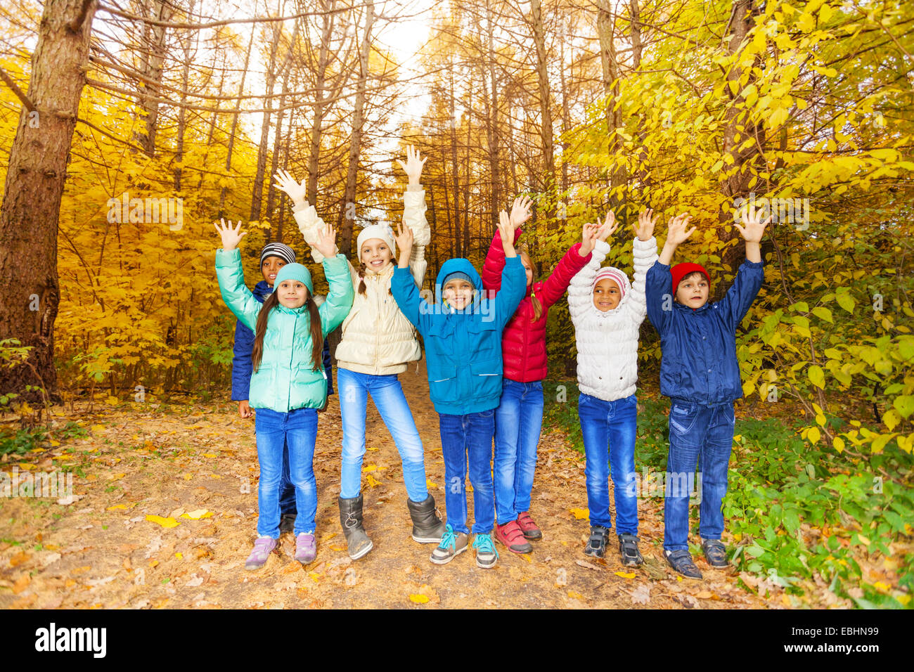Kids group with arms up standing in row together Stock Photo - Alamy