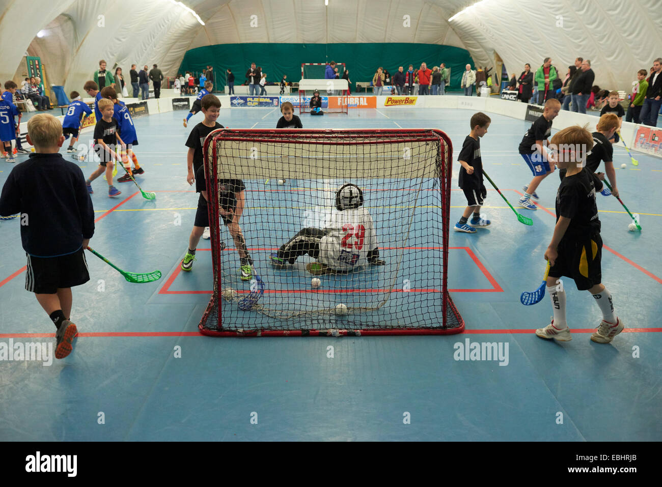 Children boys schoolchildren playing floorball (floor hockey) match in ...