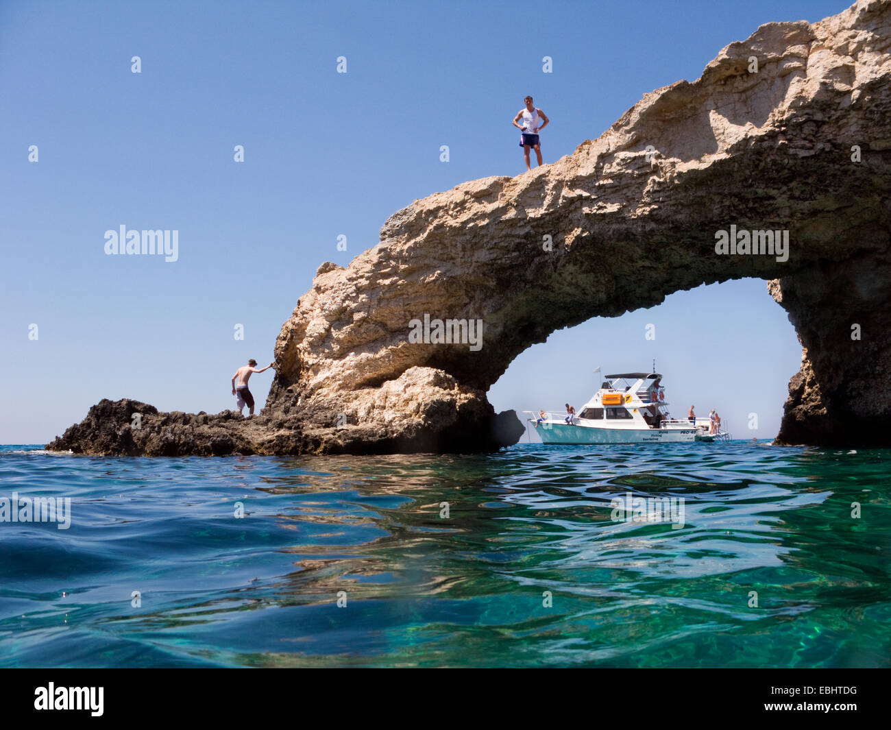 Tourists on and around the natural stone bridge at the sea caves just ...