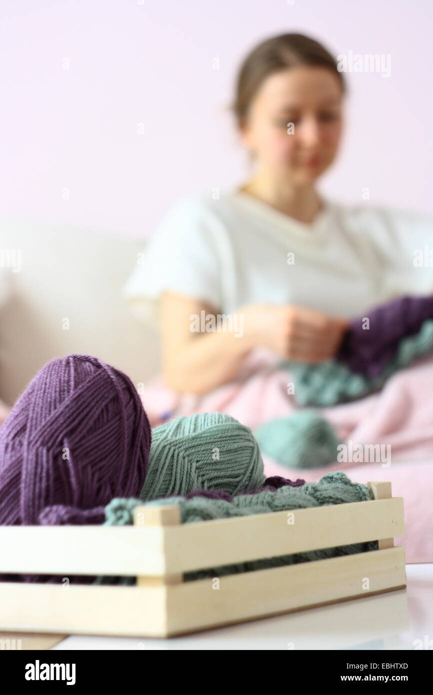 happy young woman knitting on sofa Stock Photo - Alamy