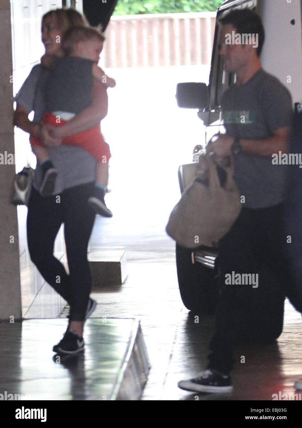 Hilary Duff carries her son into a hotel while laughing and her hair ...