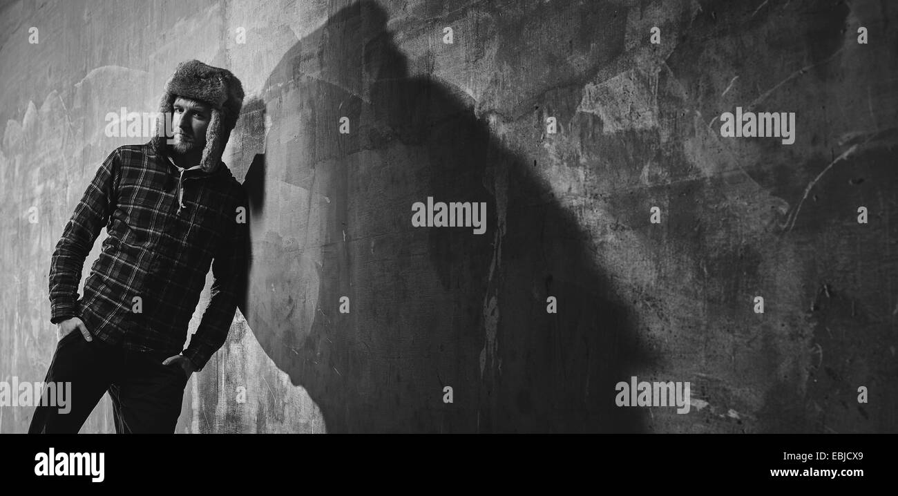 Handsome young man wearing a checked shirt and fur hat and he lean ...