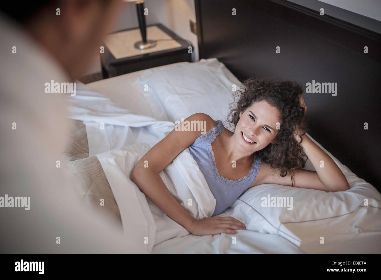 Young woman lying on bed, high angle Stock Photo - Alamy