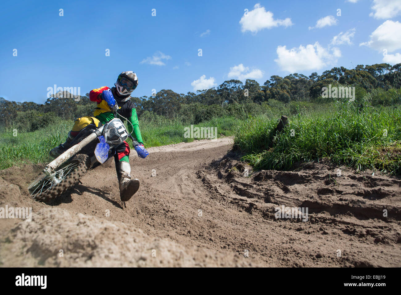 Young male motocross rider racing through mud track bend Stock Photo ...