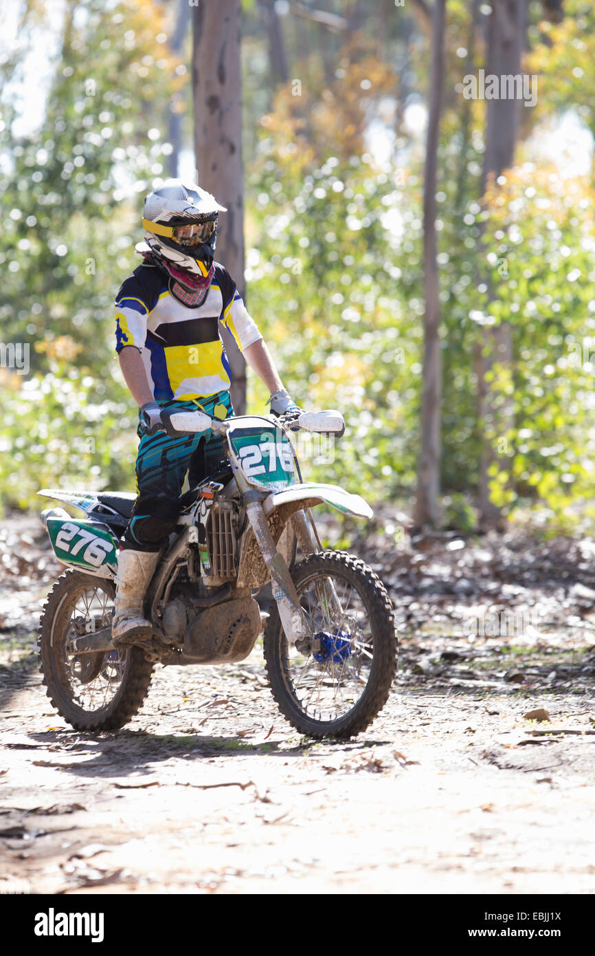 Young male motocross racer standing whilst riding through forest Stock ...