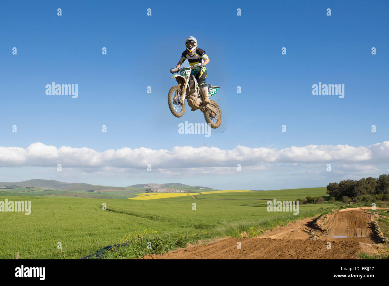 Young male motocross racer jumping mid air over landscape Stock Photo ...