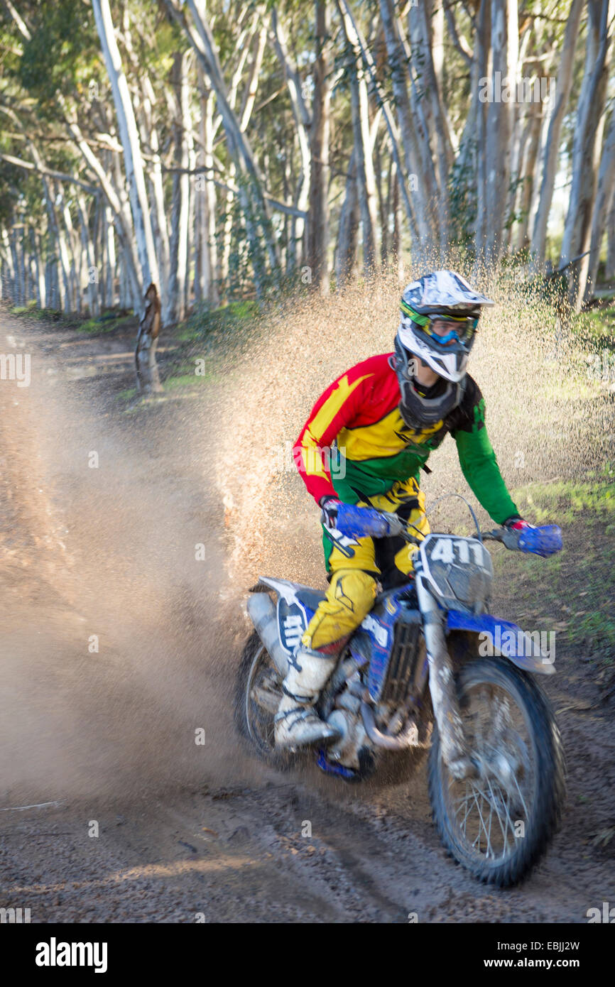 Young male motocross racer splashing through forest track Stock Photo ...