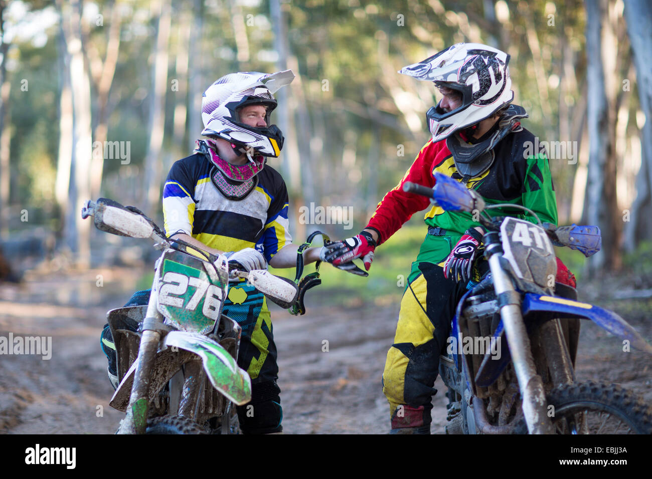 Two young male motocross riders chatting on forest track Stock Photo ...