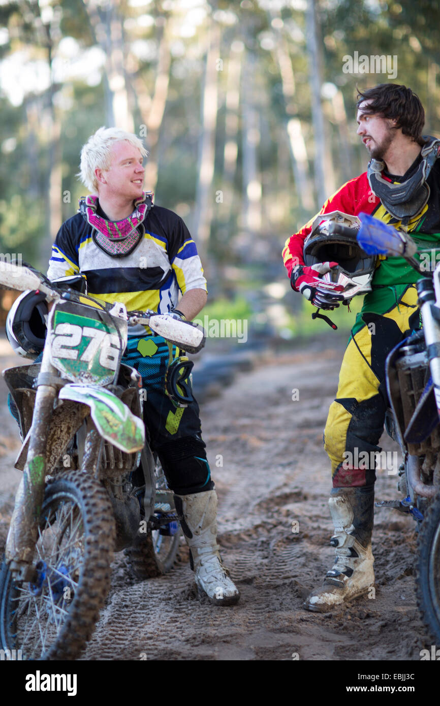 Two young male motocross competitors chatting on forest track Stock ...