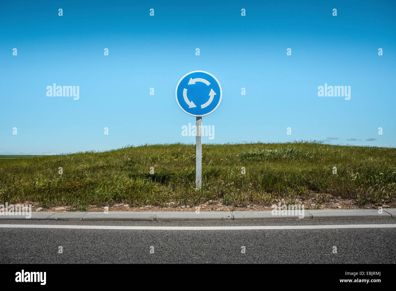 Roundabout sign by edge of road Stock Photo - Alamy