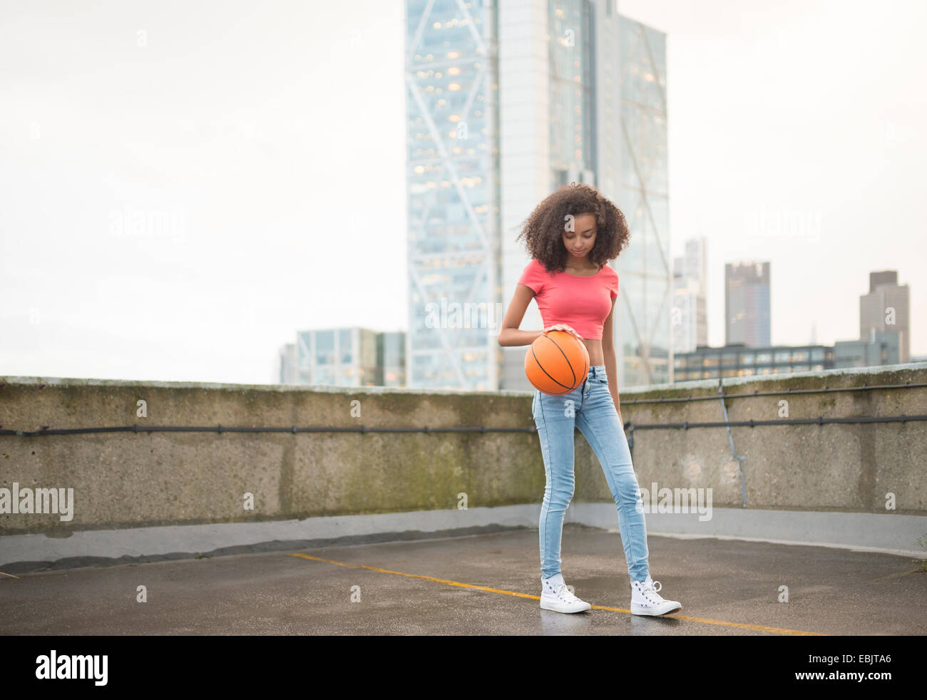 Young woman bouncing basketball Stock Photo - Alamy
