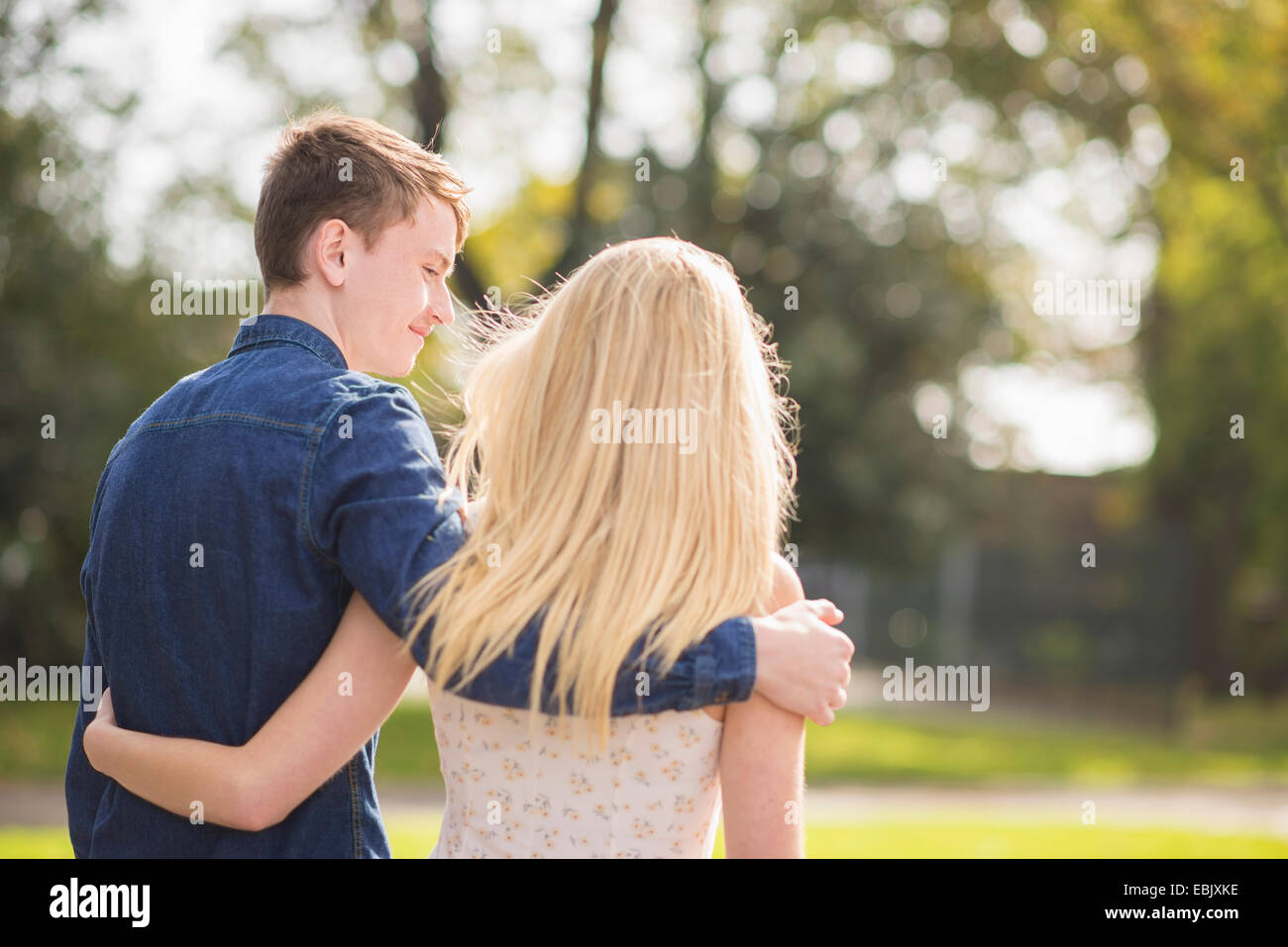 Rear view of romantic young couple strolling in park Stock Photo - Alamy
