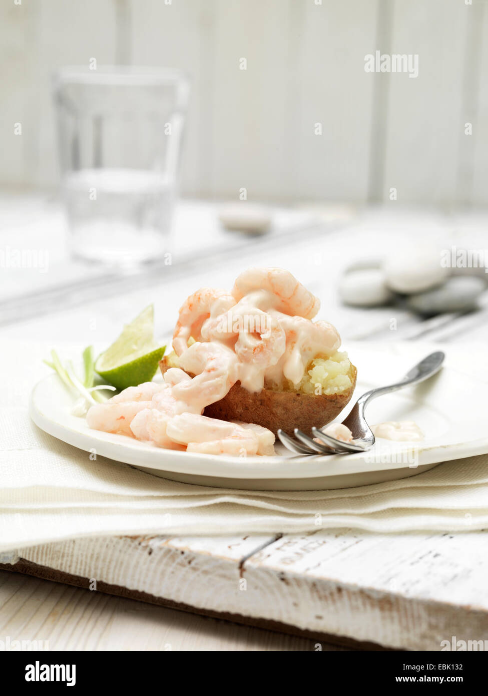 Prawn cocktail jacket potato with slice of lime and spring onion ...