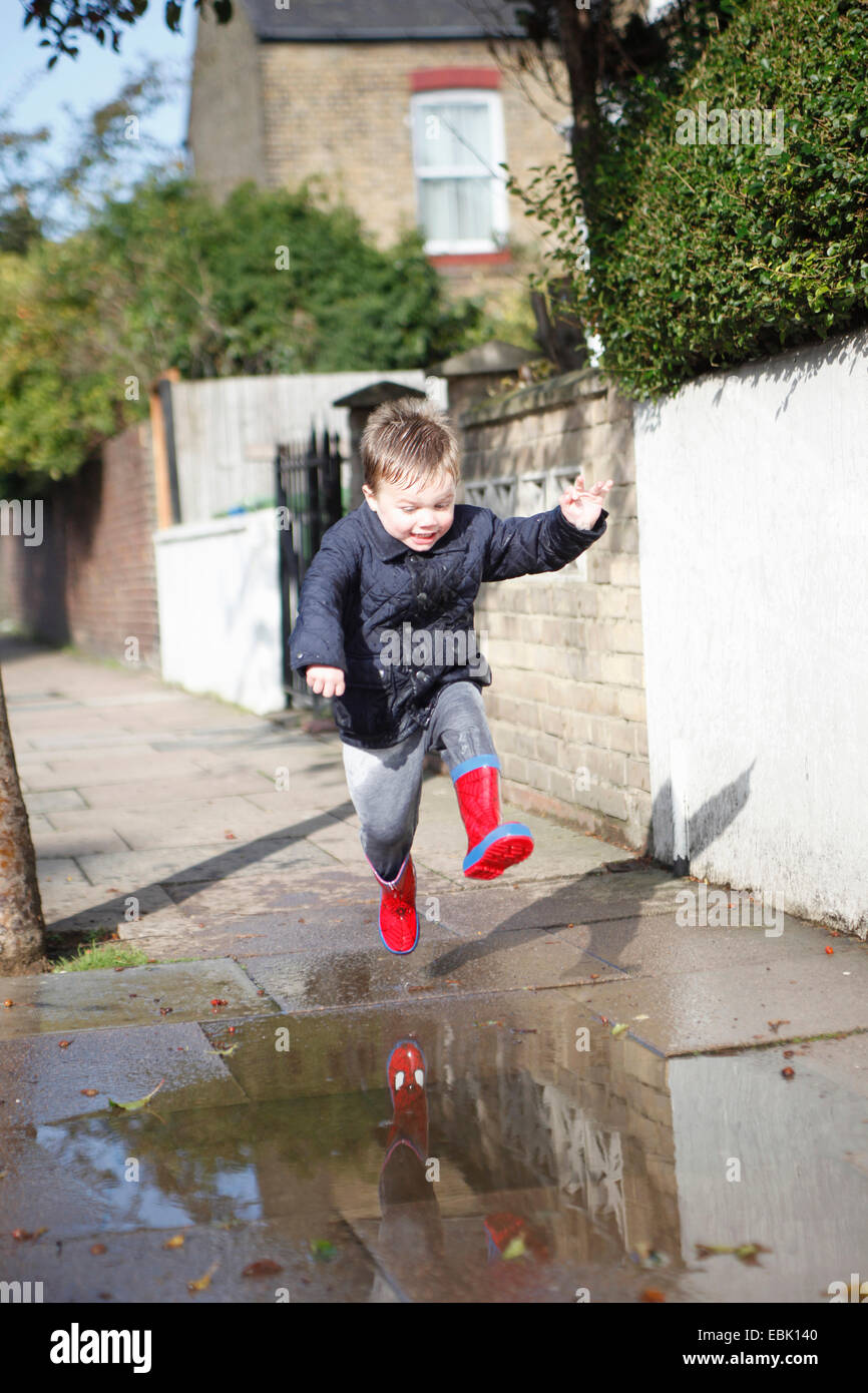 Boy jumping in puddle hi-res stock photography and images - Alamy