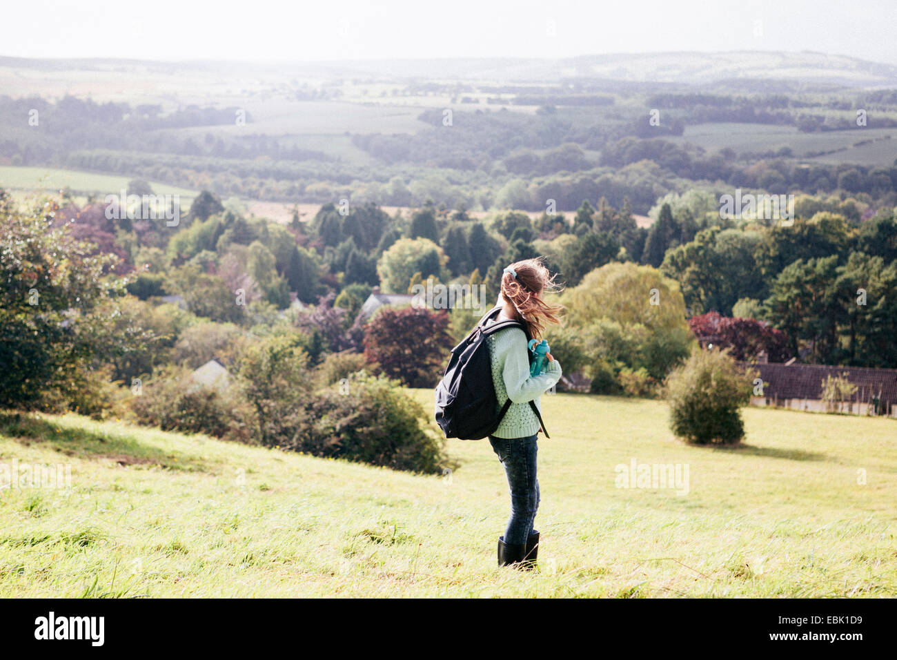 Girl standing in field looking at view Stock Photo - Alamy