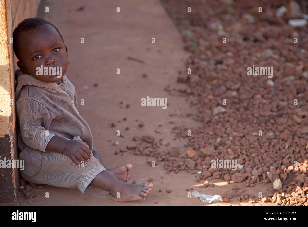 orphan child sitting on concrete ground at the local orphanage, Burundi ...