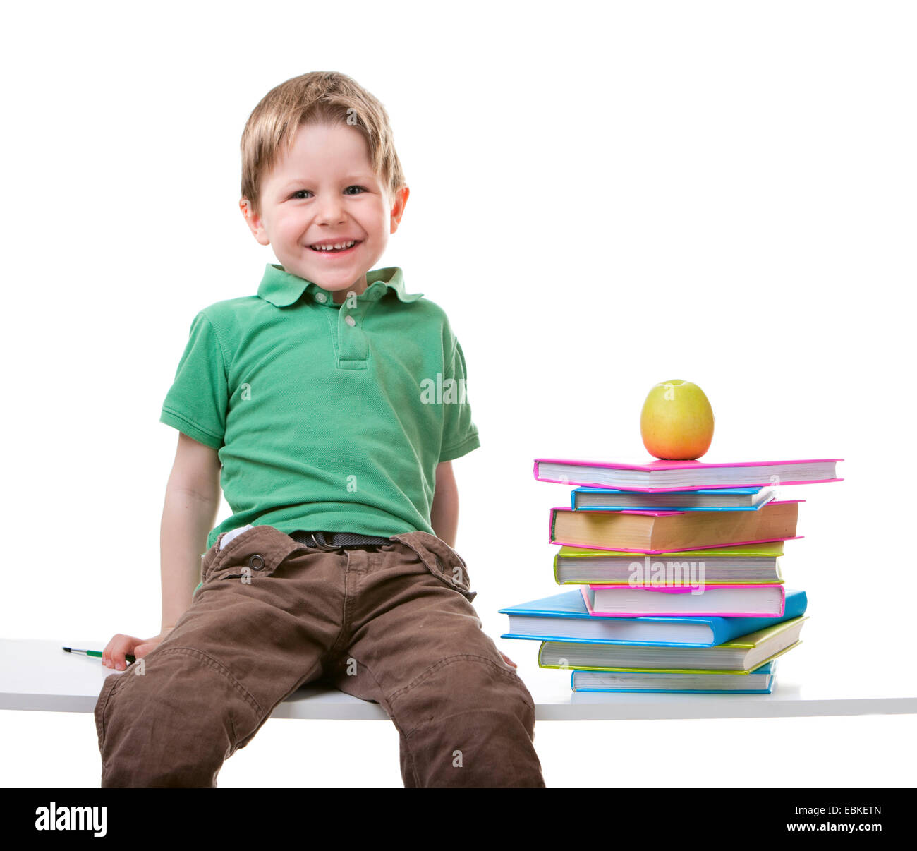Little boy with books with a pile of books and an apple Stock Photo - Alamy