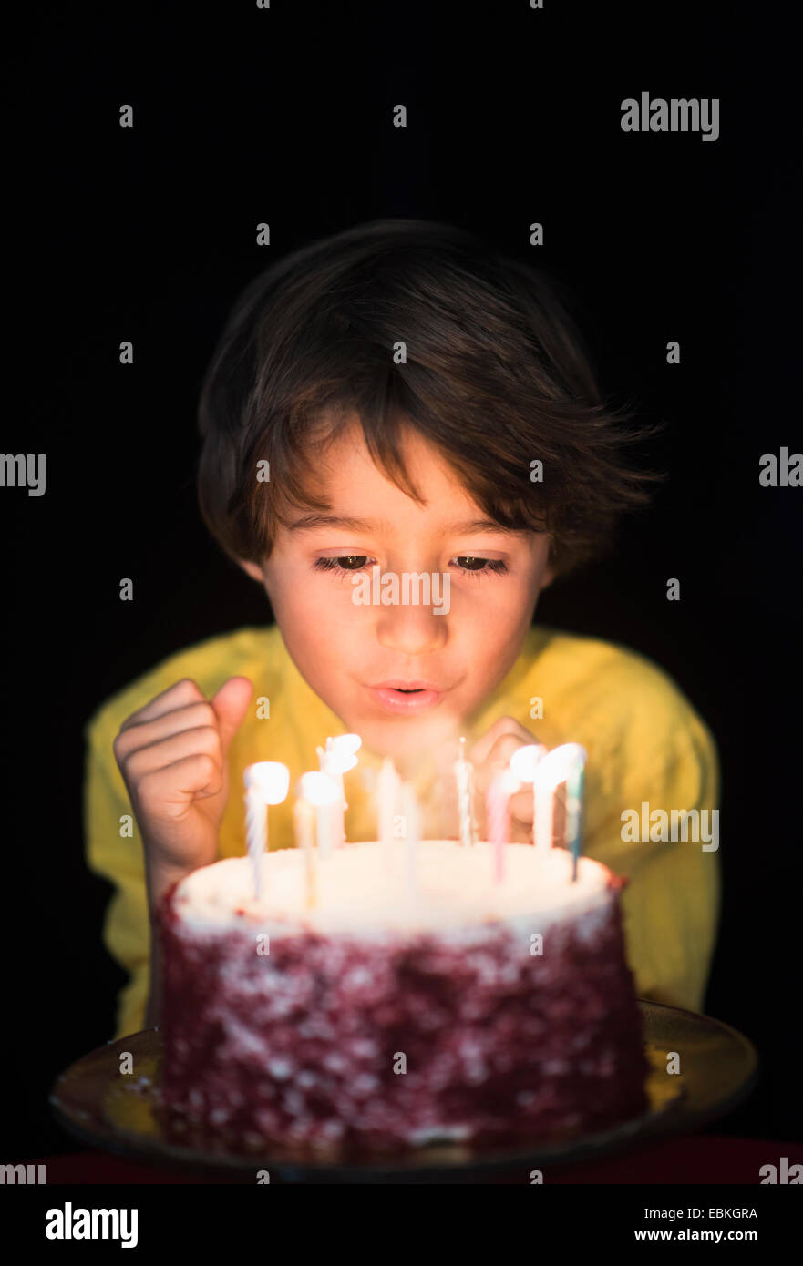 Portrait of boy (6-7) blowing out birthday candles Stock Photo - Alamy