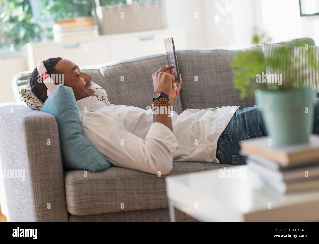 Man relaxing on sofa with tablet pc Stock Photo - Alamy