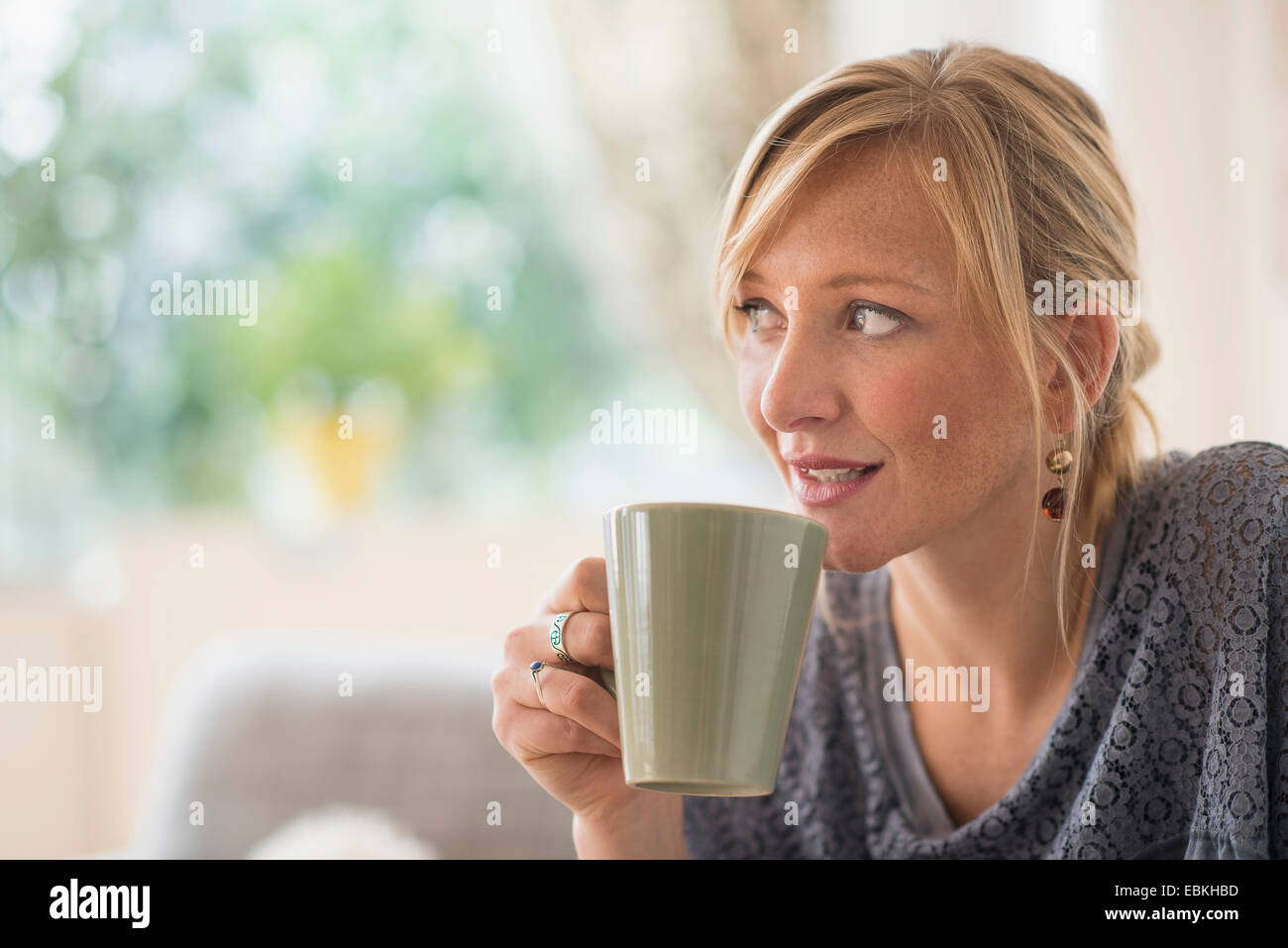 Pensive woman drinking coffee Stock Photo - Alamy
