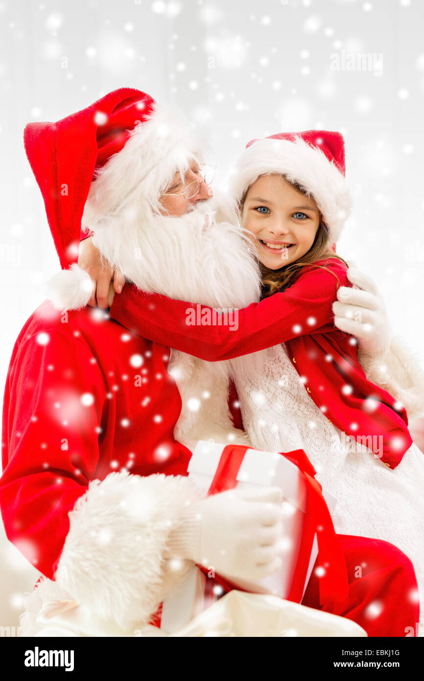 smiling girl hugging santa claus with gift at home Stock Photo - Alamy
