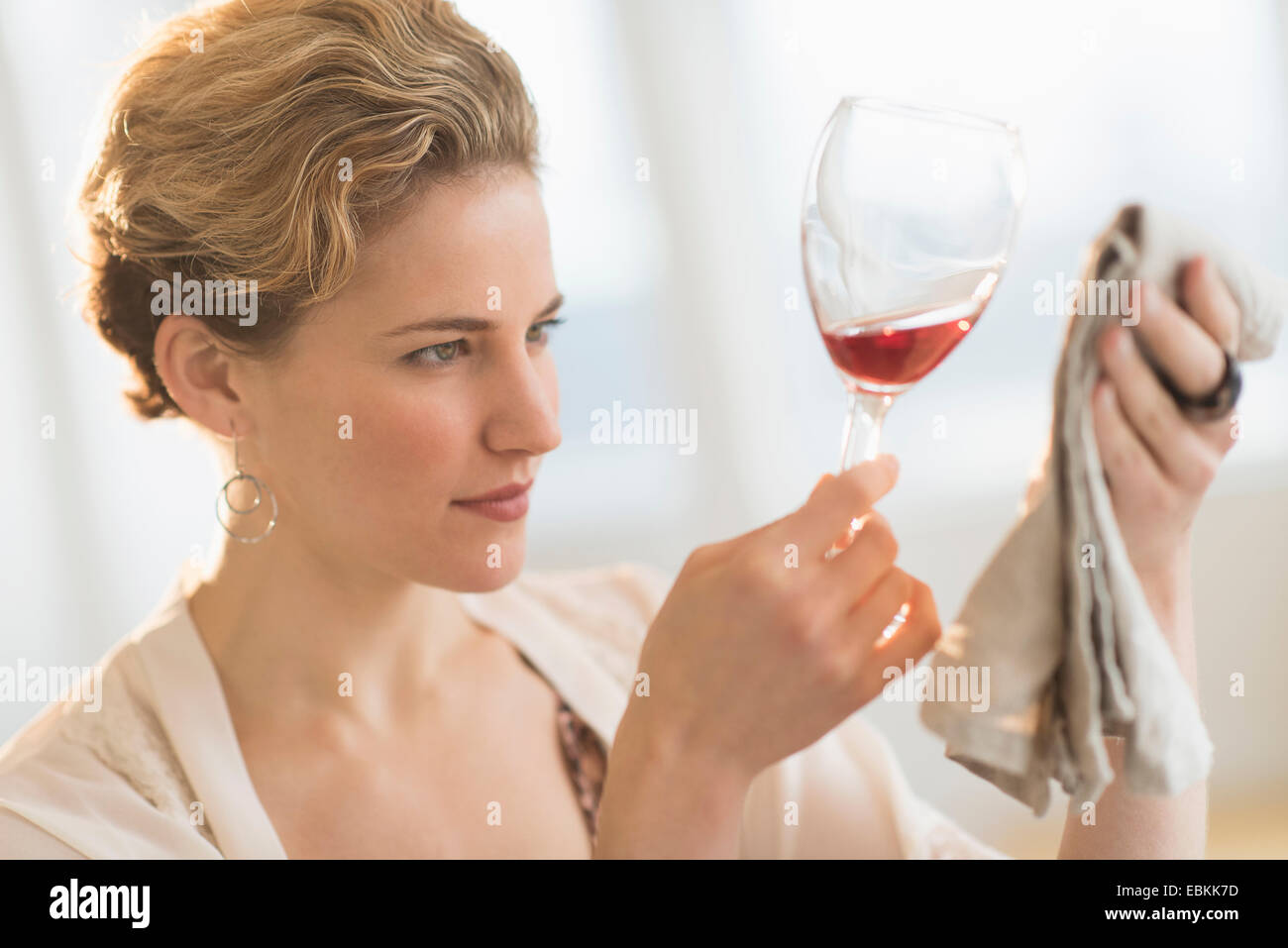 Young woman looking closely at red wine Stock Photo - Alamy