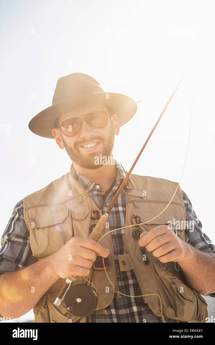 Portrait of man holding fishing rod Stock Photo - Alamy