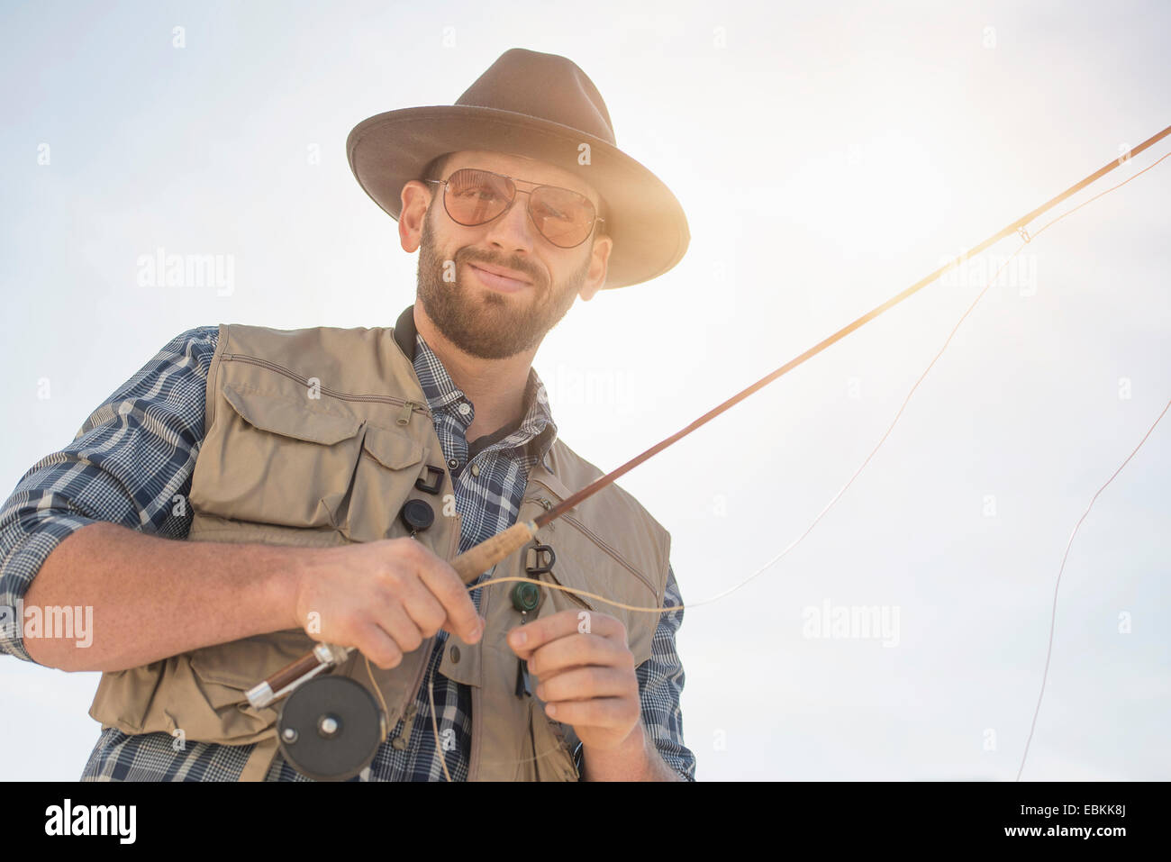 Portrait of man holding fishing rod Stock Photo - Alamy
