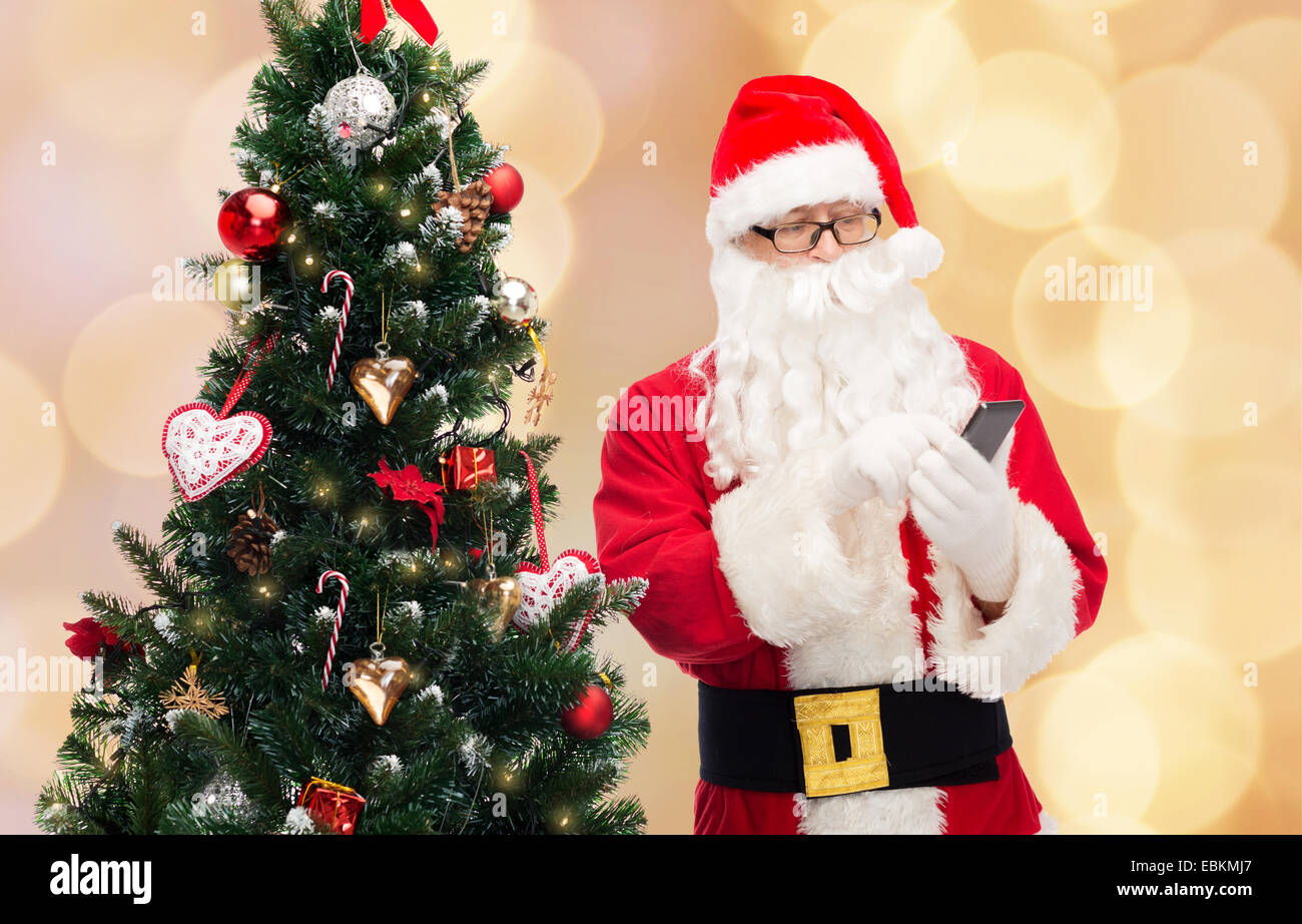 santa claus with smartphone and christmas tree Stock Photo - Alamy