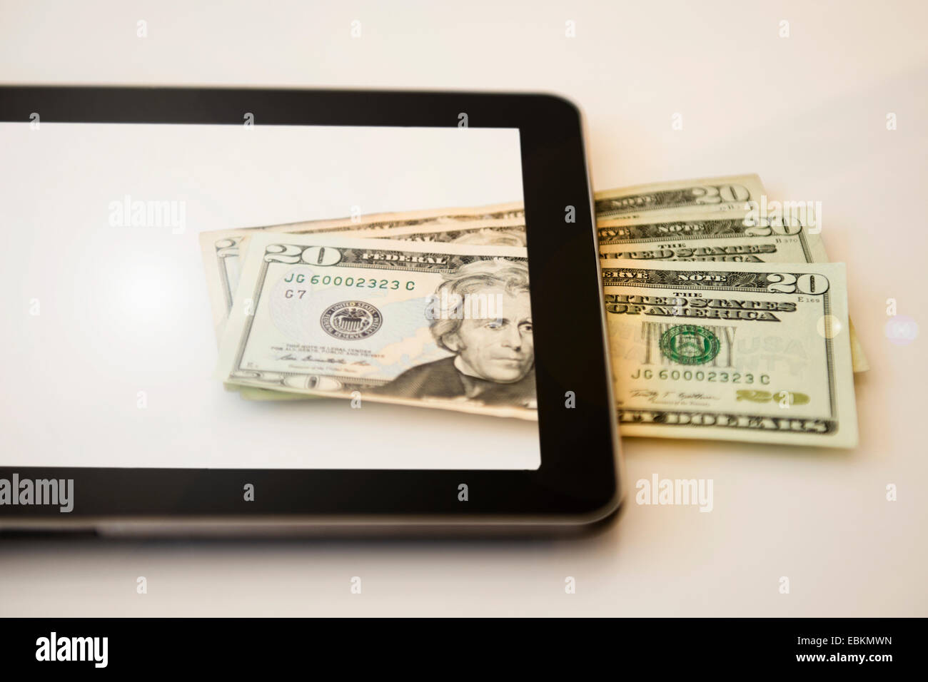 Digital tablet and twenty dollar bills Stock Photo - Alamy