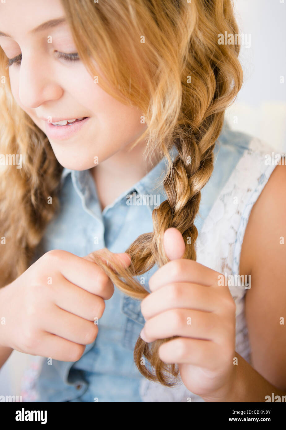 Girl (12-13) plaiting braids Stock Photo - Alamy