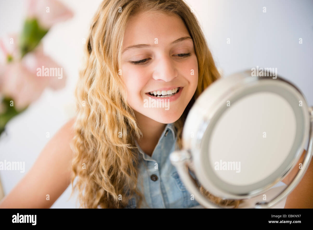 Girl (12-13) smiling to mirror Stock Photo - Alamy