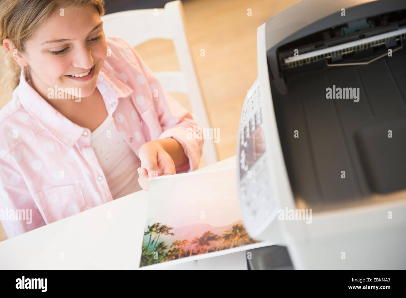 Girl (12-13) waiting for photo next to printer Stock Photo - Alamy