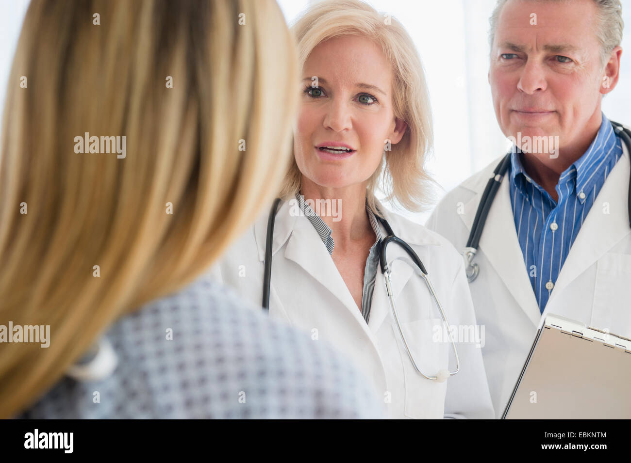 Three medical practitioners looking away against gray background Stock ...