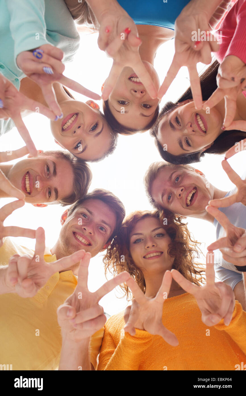 group of smiling teenagers showing victory sign Stock Photo - Alamy