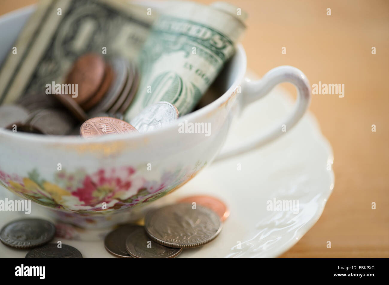 Studio shot of money in tea cup Stock Photo - Alamy