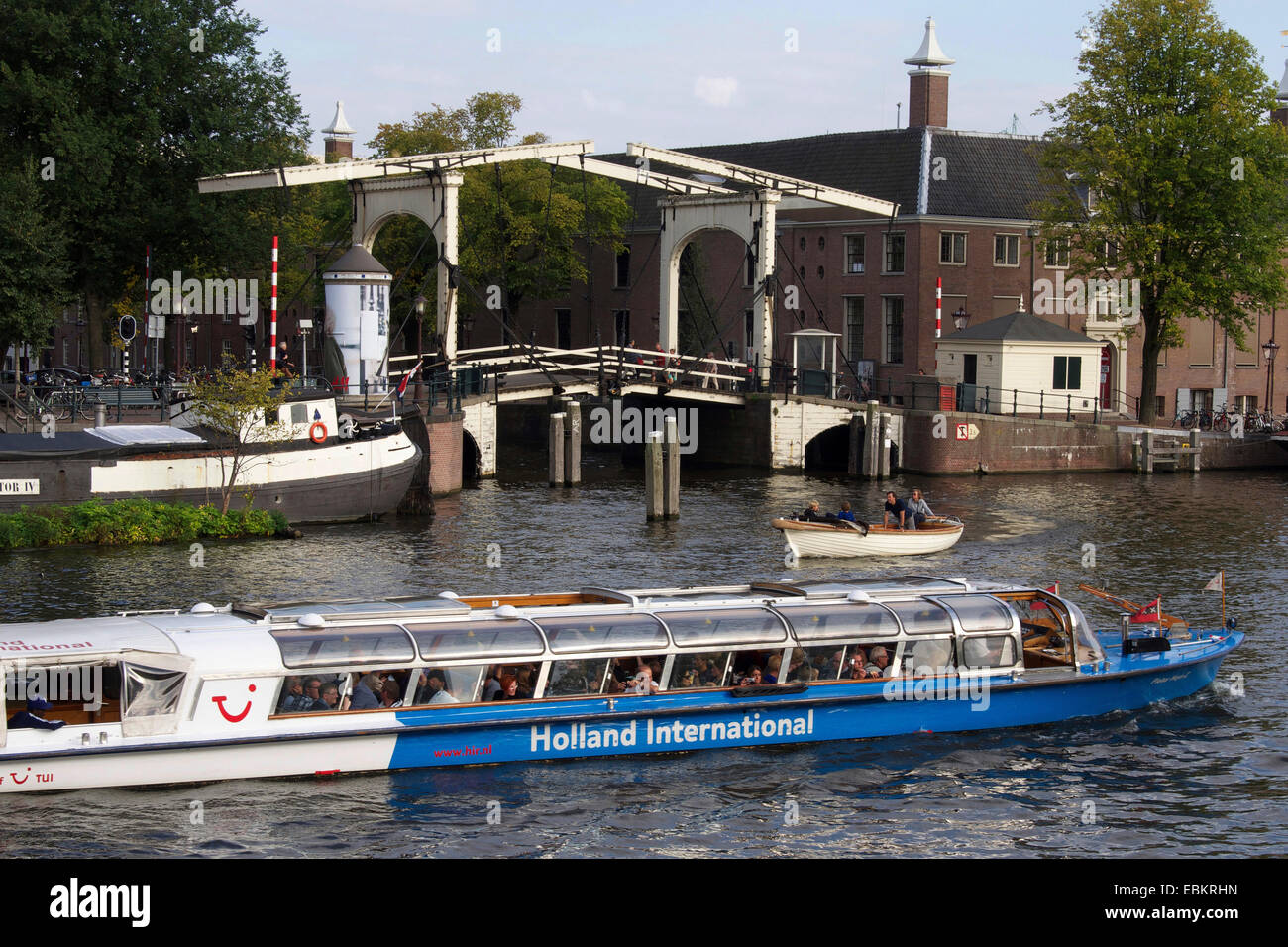 Wooden cantilever bridge over the Amstel River with boats cruising in ...