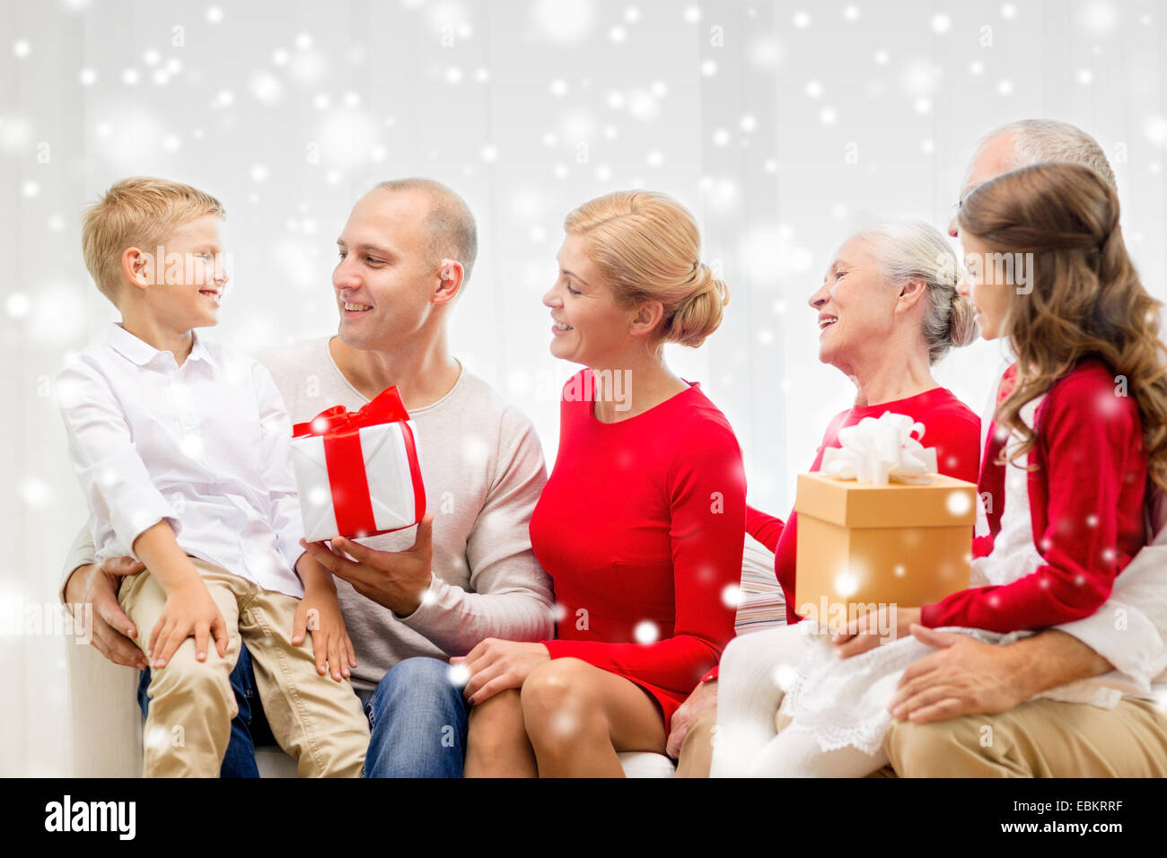 smiling family with gifts talking at home Stock Photo - Alamy