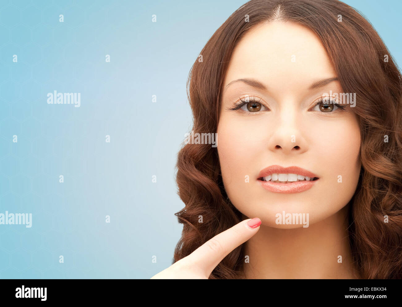 beautiful young woman pointing finger to her chin Stock Photo - Alamy