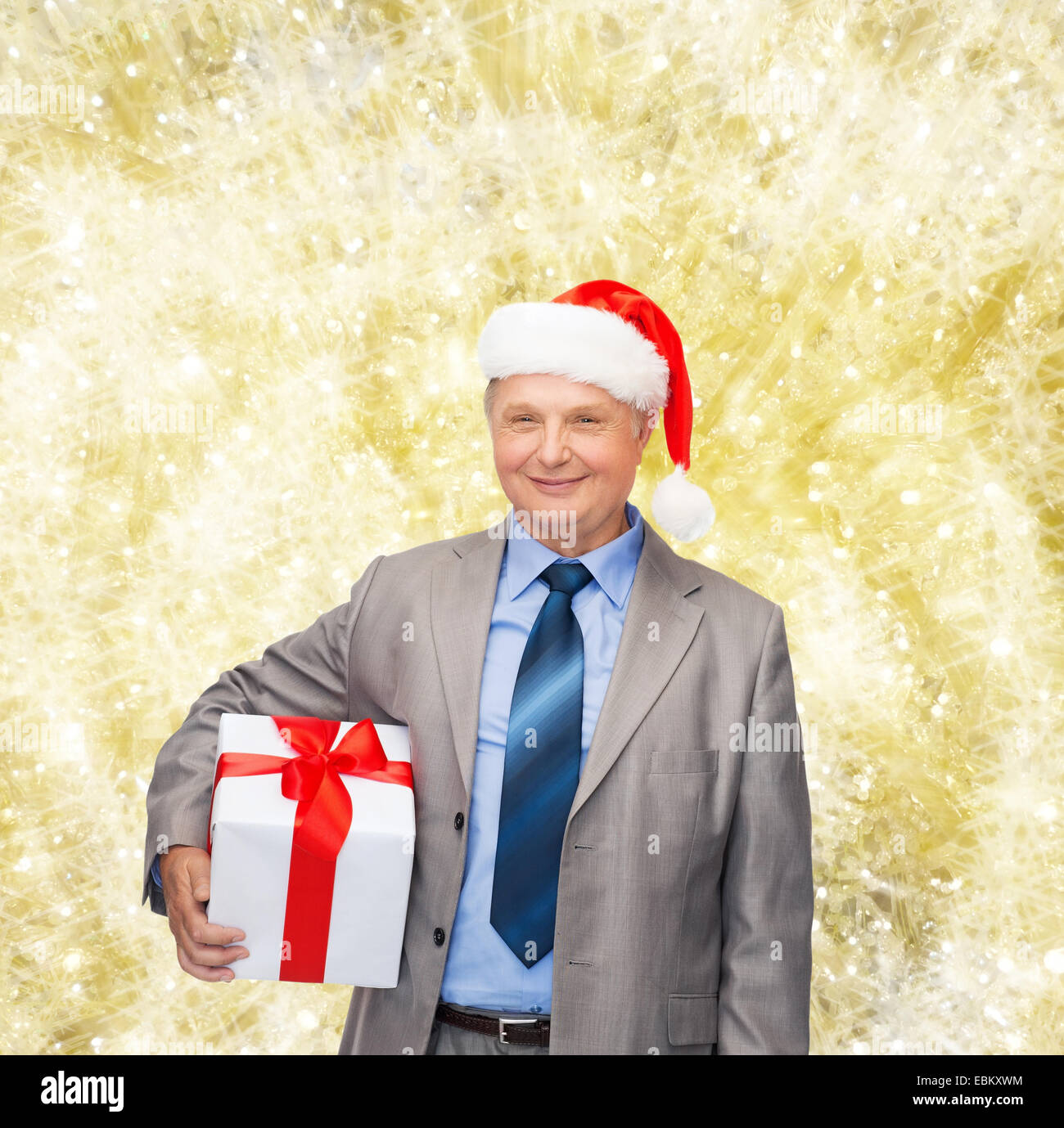 smiling man in suit and santa helper hat with gift Stock Photo - Alamy