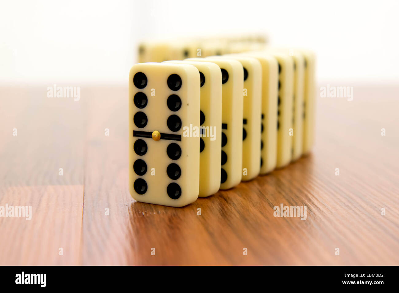 Domino tiles standing vertically in a line Stock Photo - Alamy