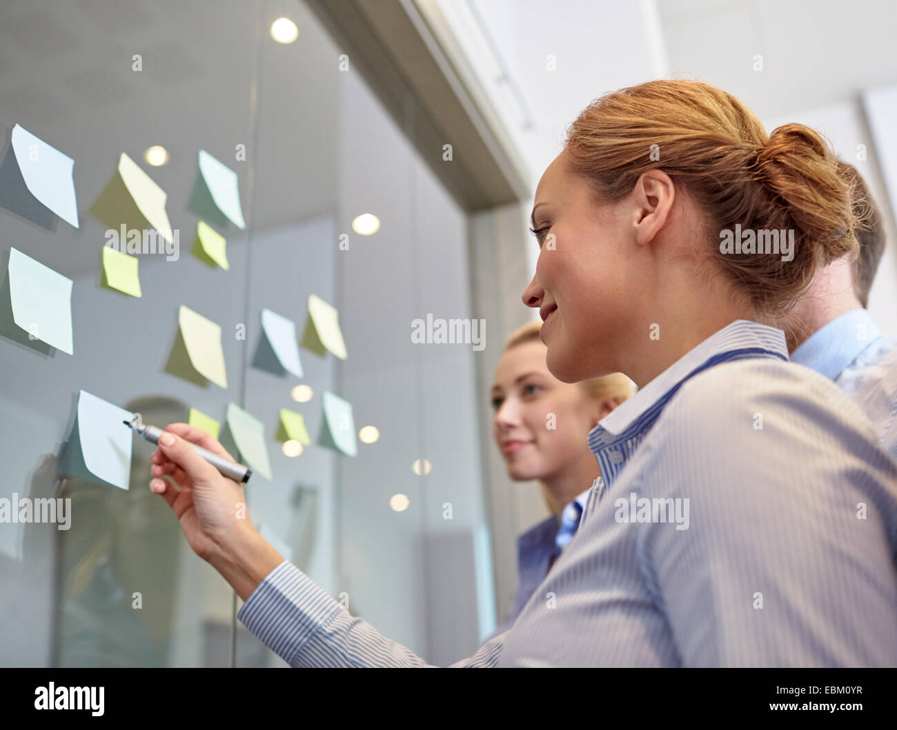 smiling business people with marker and stickers Stock Photo - Alamy