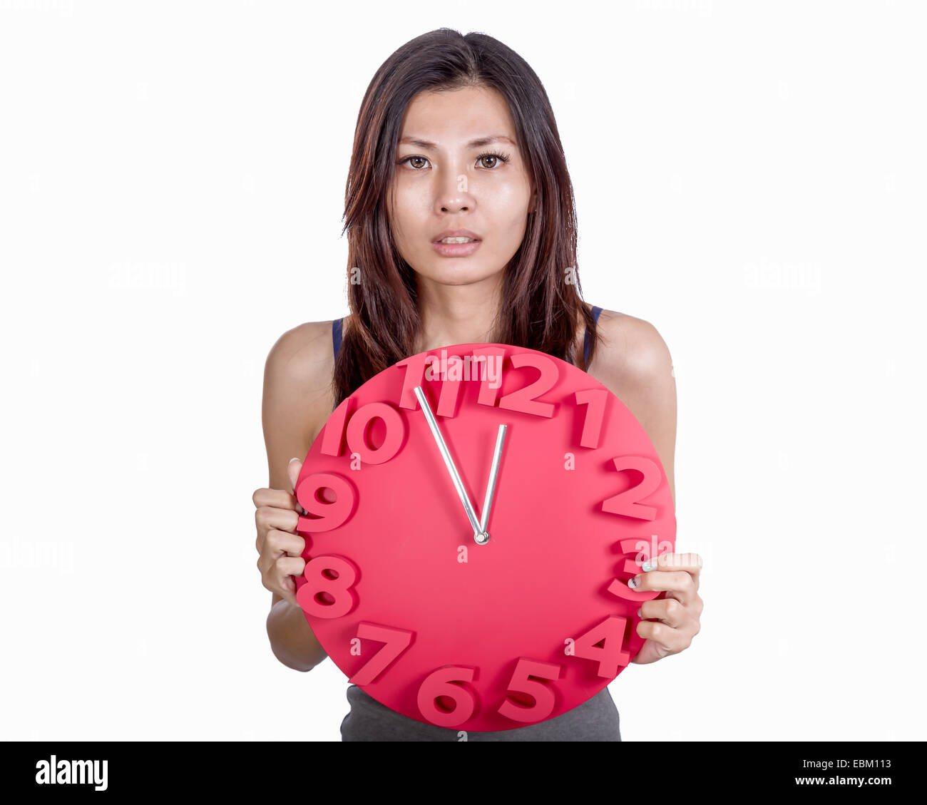 Chinese woman looking tense, holding clock showing five to midnight ...