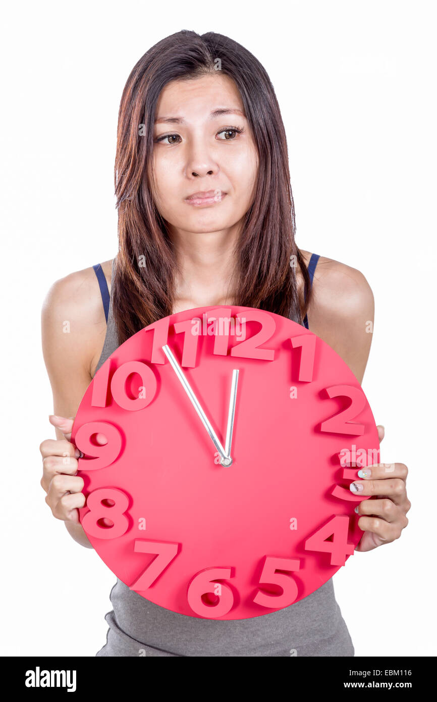 Chinese woman looking worried, holding clock showing five to twelve ...