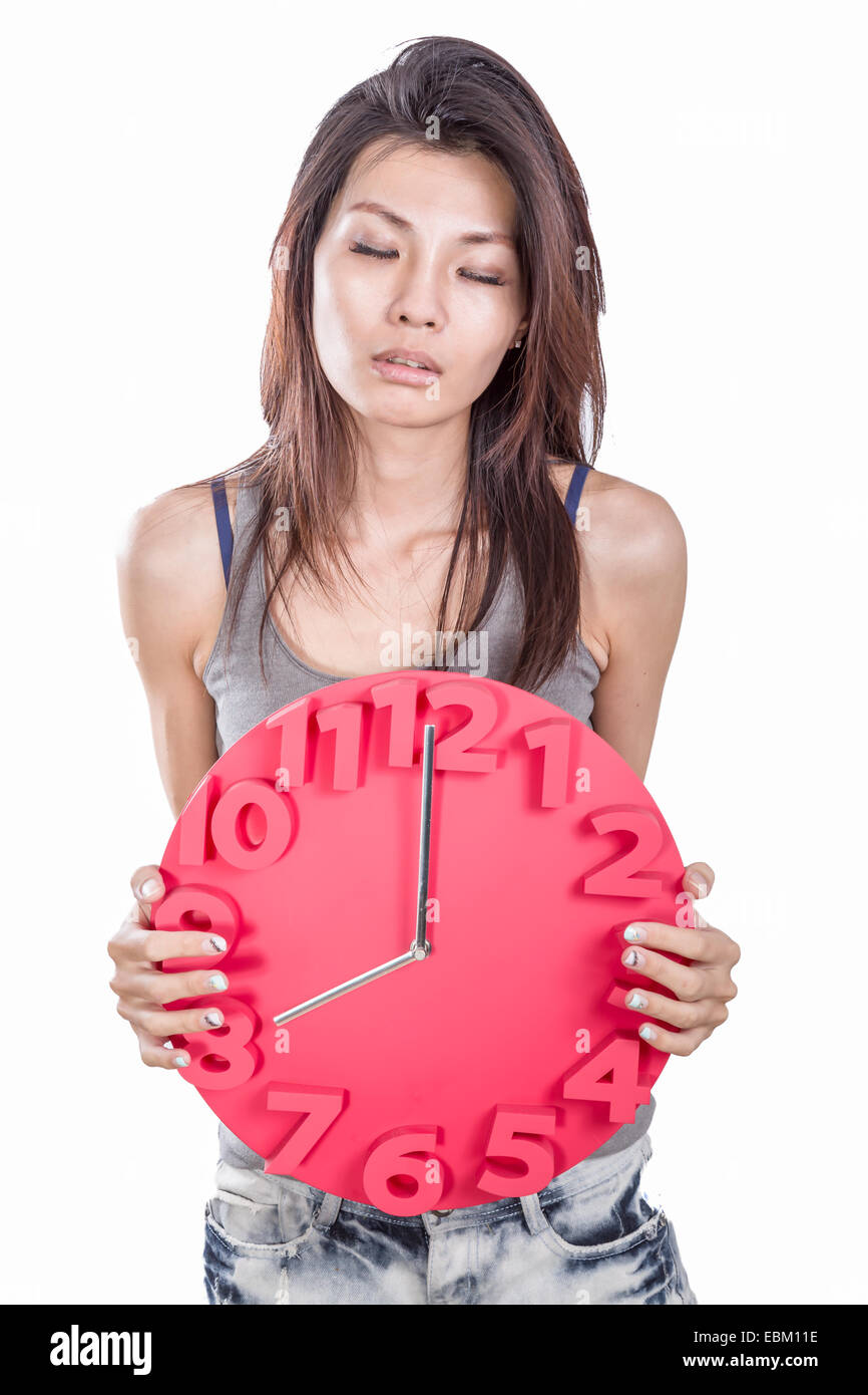 Chinese woman looking tired holding clock showing eight o' clock ...