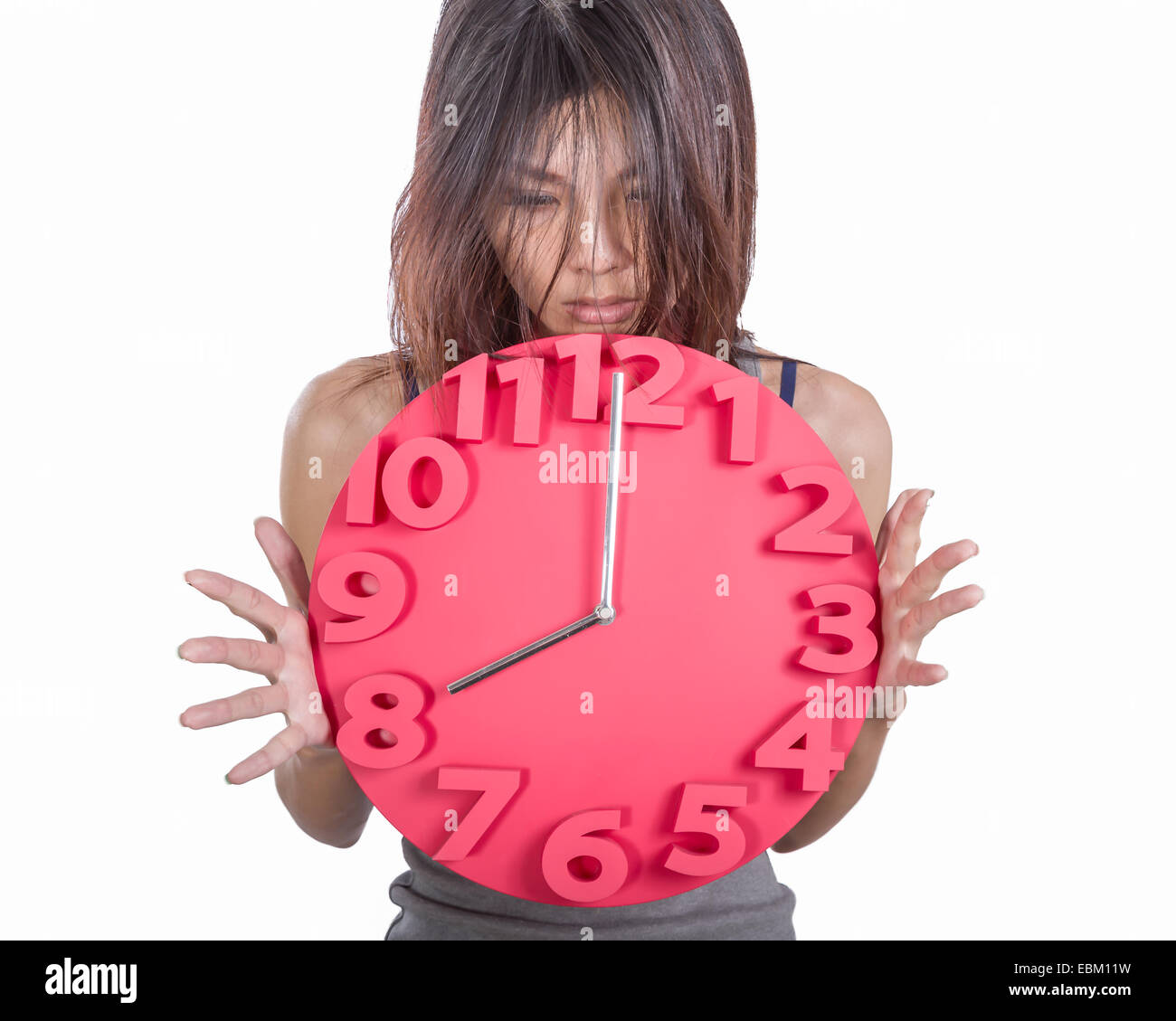 Chinese woman looking tired holding clock showing eight o' clock ...