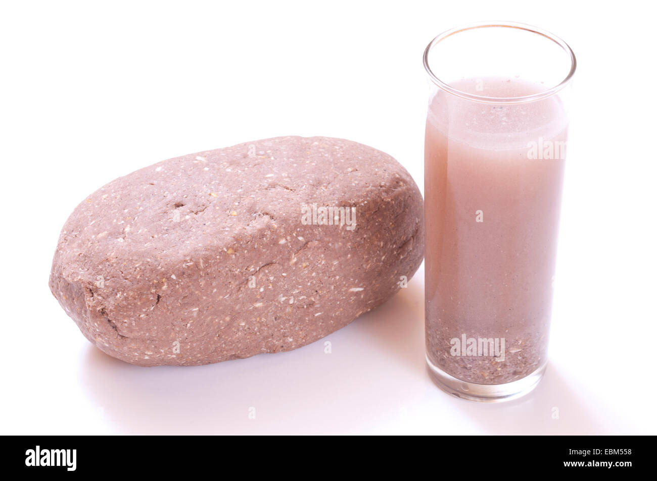 Fresh made block of Mexican pozol and glass of same beverage consisting ...